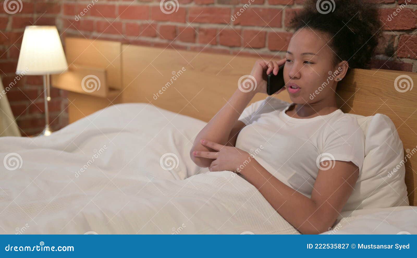 African Woman Talking on Call on Smartphone in Bed Stock Video - Video ...