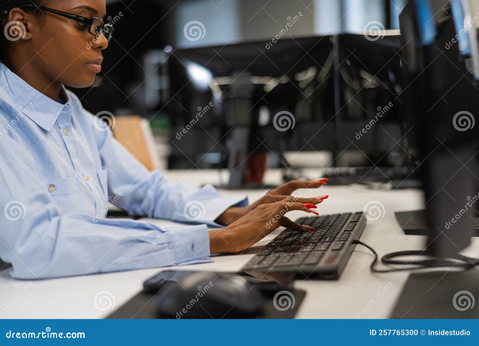 African Young Woman Typing on a Computer at Her Desk in the Office ...