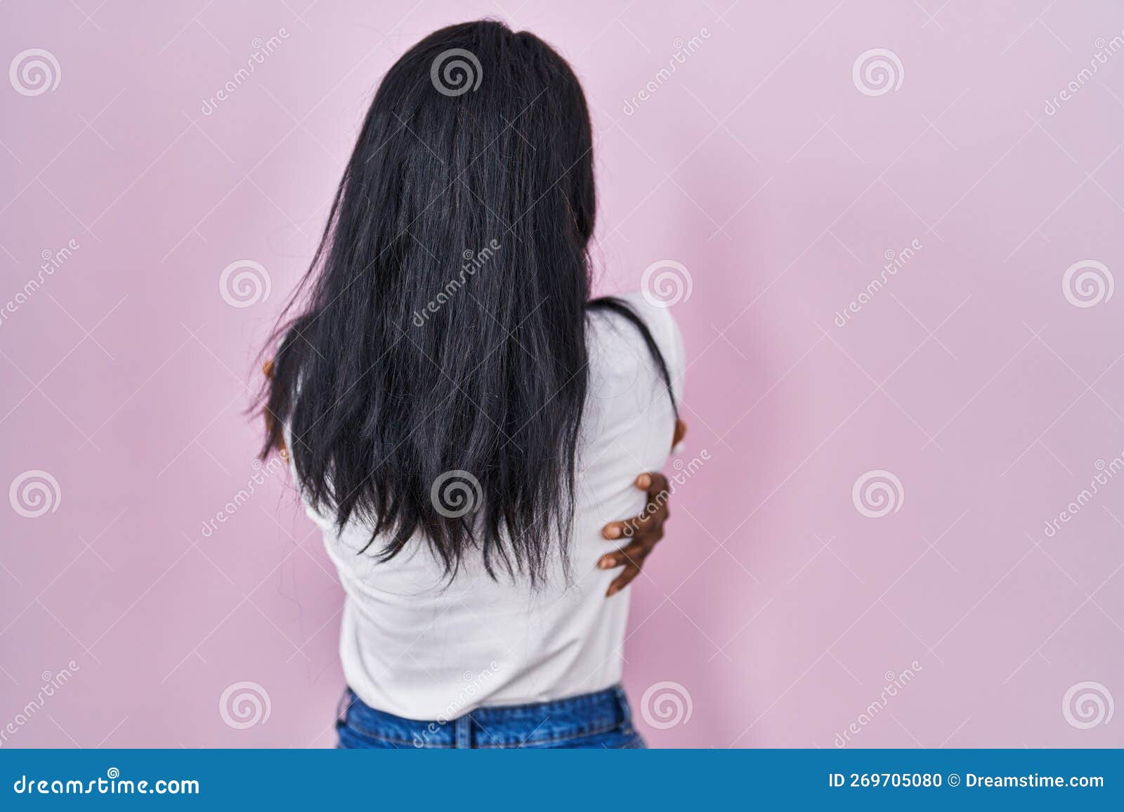 African Young Woman Wearing Casual White T Shirt Hugging Oneself Happy