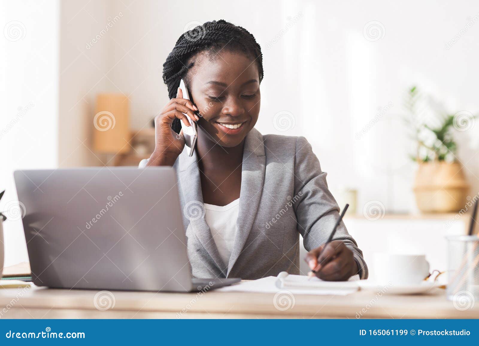 Afro Secretary Taking Notes and Talking on Cellphone in Office Stock ...