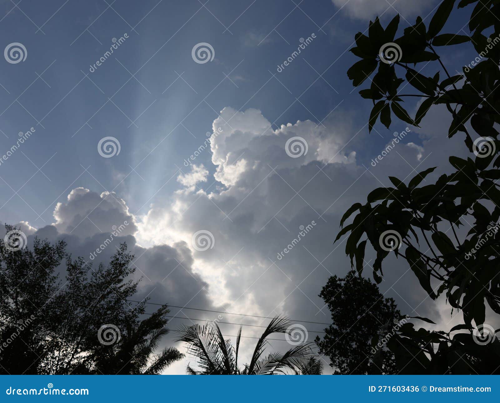 Afternoon Sun Rays Behind the Clouds on a Blue Sky Background Stock ...