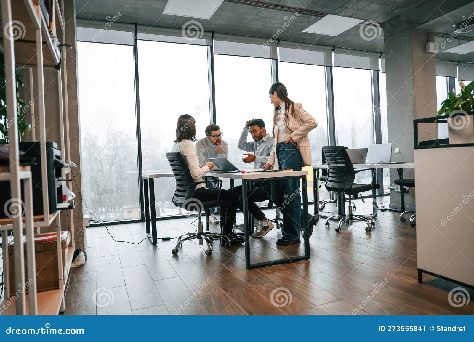Against Big Windows by the Table. Four People are Working in the Office ...