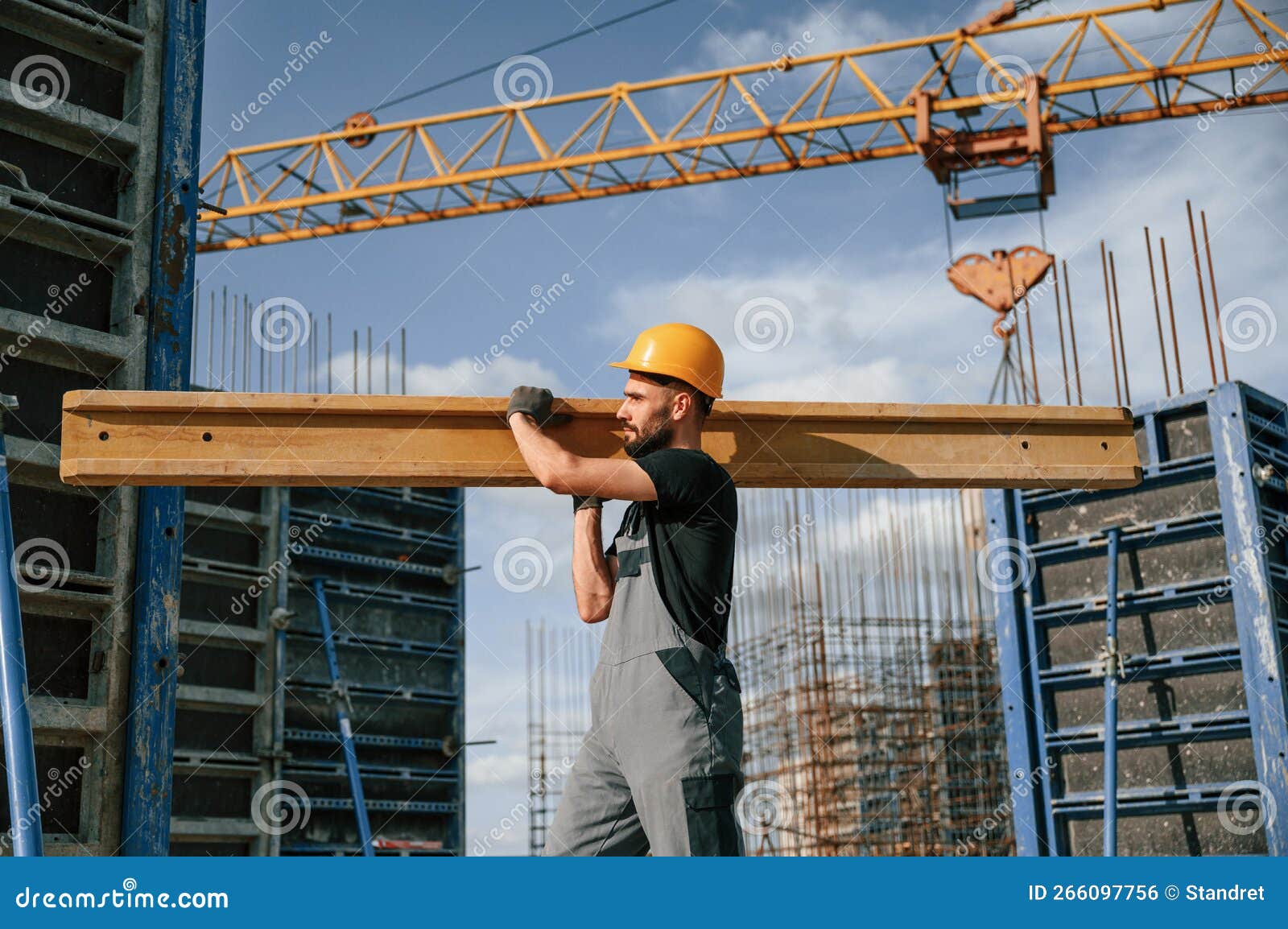 Against Crane with Wooden Plank. Man in Uniform is Working on the ...