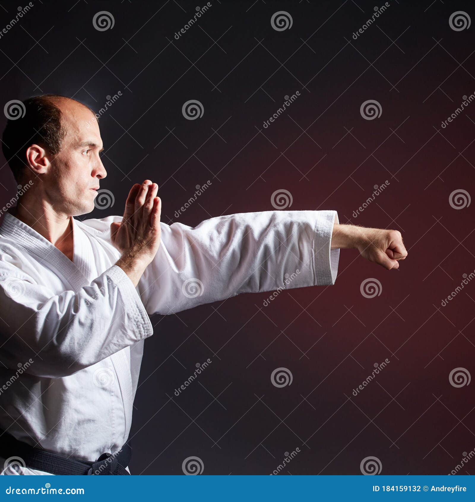Against a Dark Red Background, a Young Athlete Makes a Punch Arm Stock ...