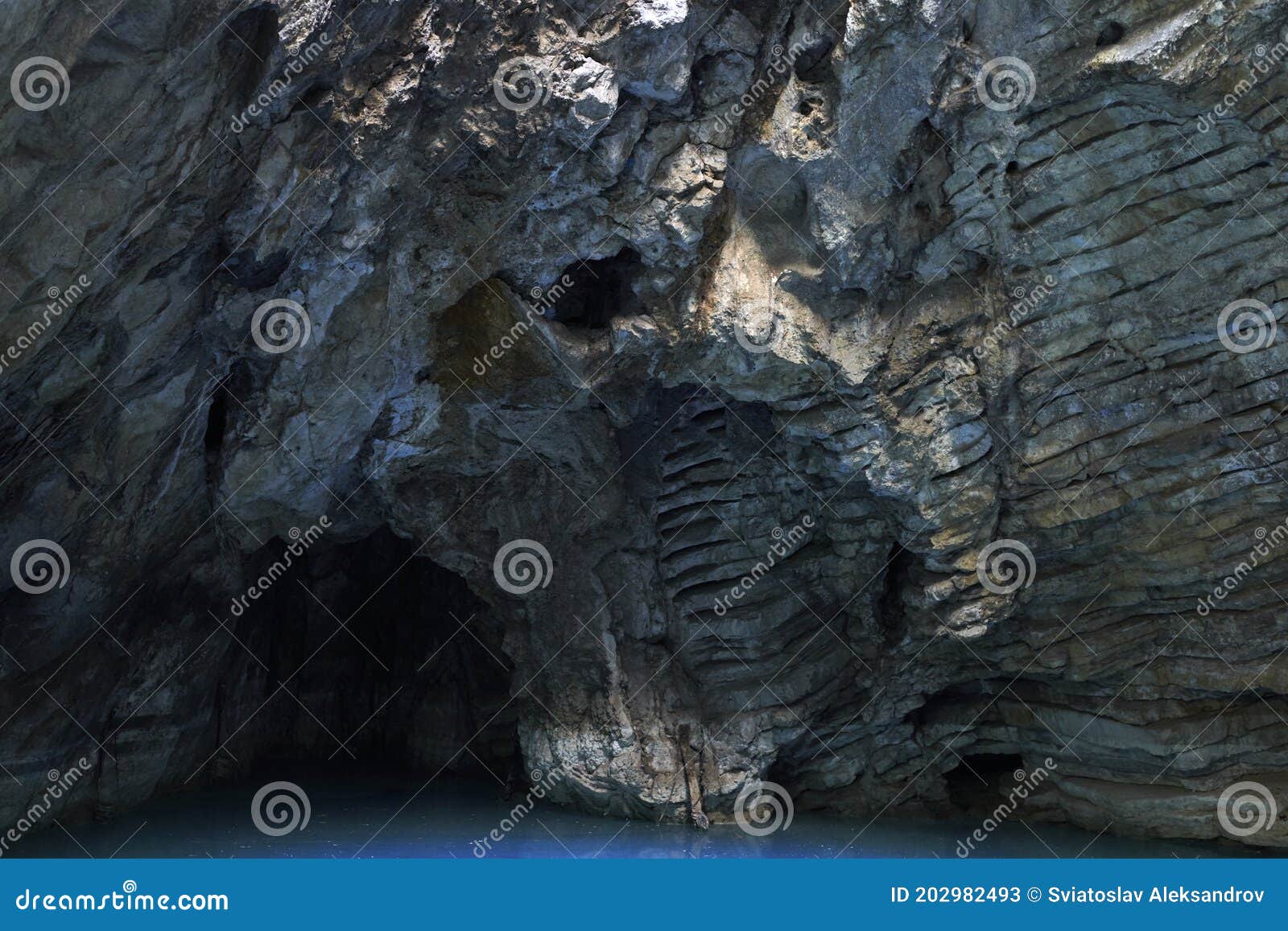An Aged Cave Interior. a Rock Wall and a Lake Stock Image - Image of ...