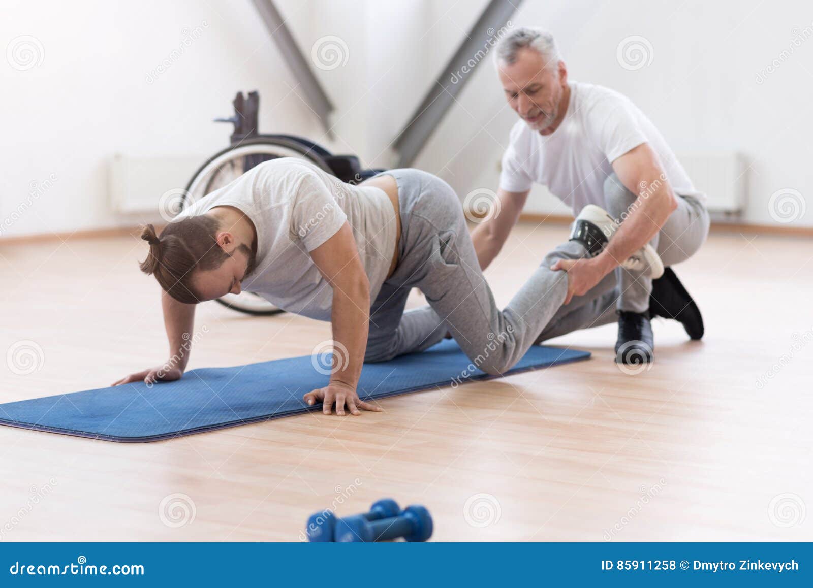 Aged Physical Therapist Stretching The Handicapped In The Gym Stock