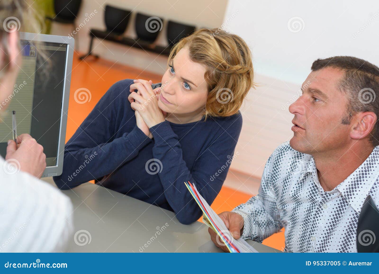Agent Explaining Details Contract To Young Couple in Office Stock Image ...