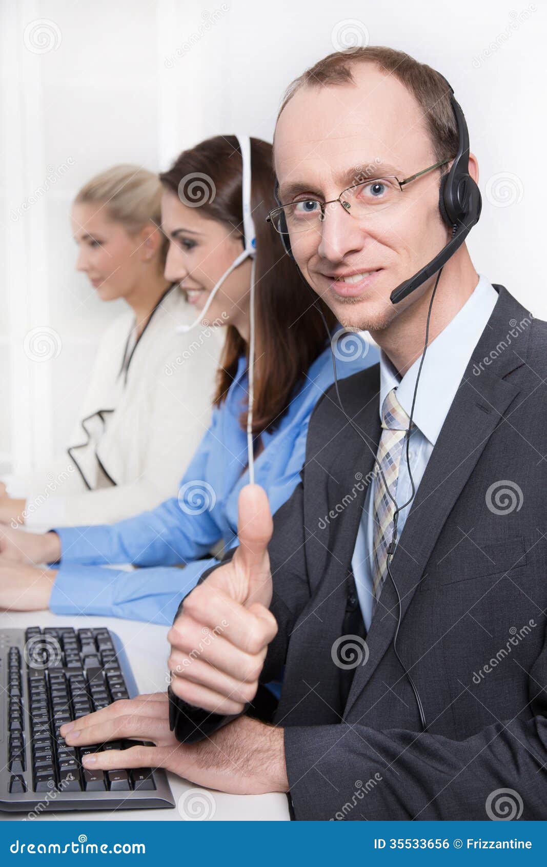 Agent Smiling while Working on His Computer in a Call-center. Stock ...