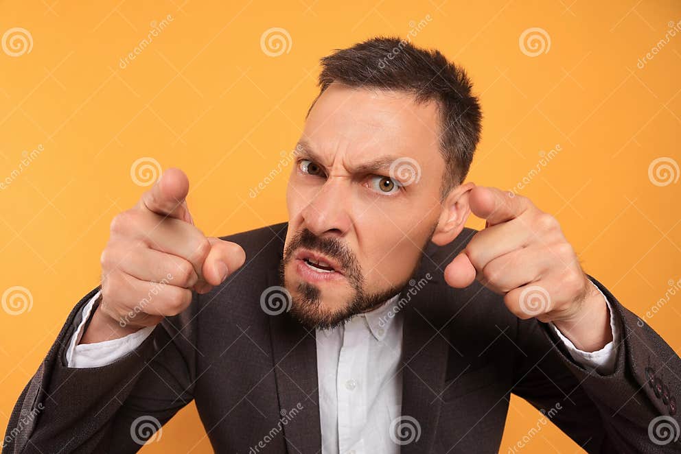 Aggressive Man Pointing on Orange Background. Hate Concept Stock Photo ...
