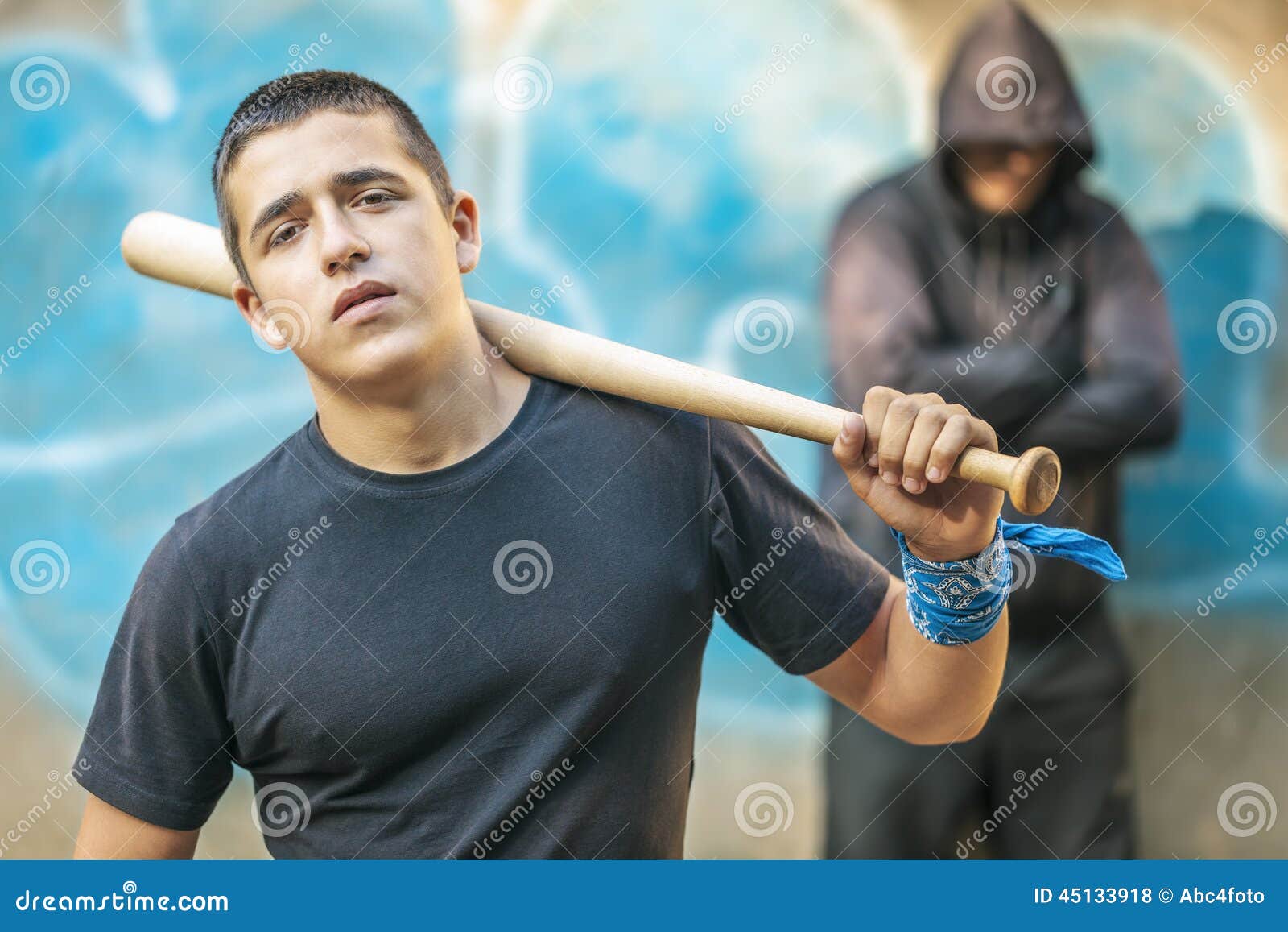 Aggressive Teenager with a Baseball Bat on Building Background Stock ...