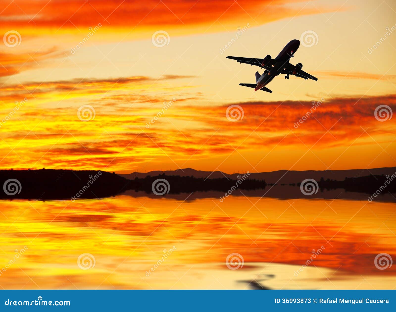 An Airplane Flying Across the Lake Stock Image - Image of sunset ...