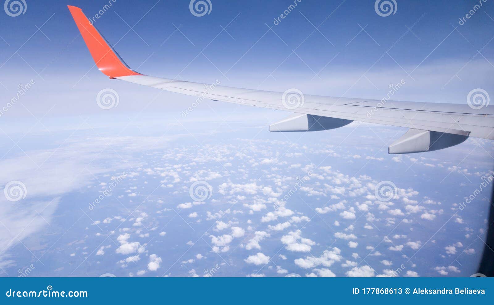 An Airplane Wing, Bright Blue Sky and Small Feather Clouds. Flight on a ...