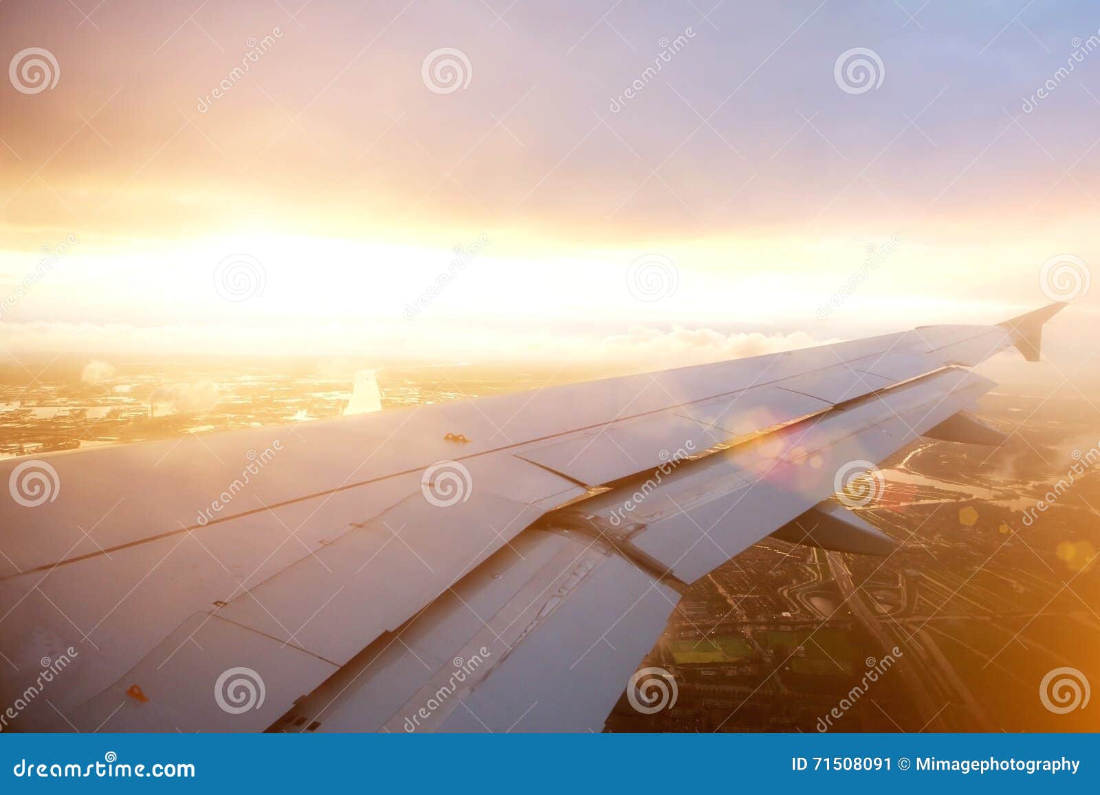 Airplane Wing Descending through the Clouds at Sunset Stock Image ...
