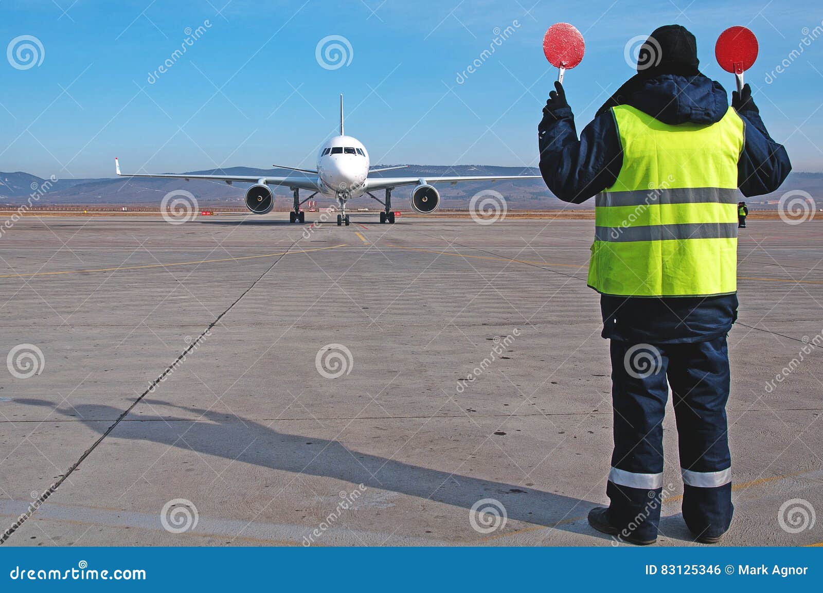 Airport worker directing stock photo. Image of light - 83125346