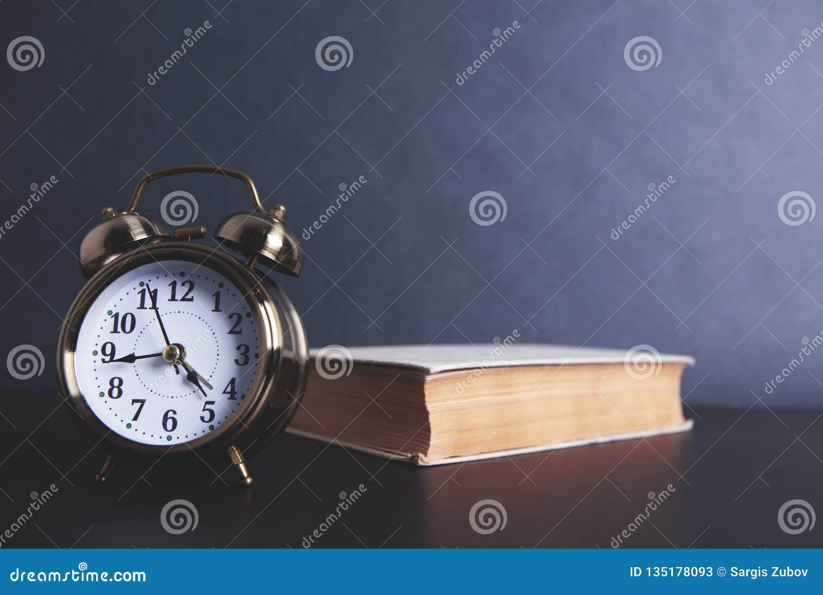 Alarm clock a book stock image. Image of time, closeup - 135178093