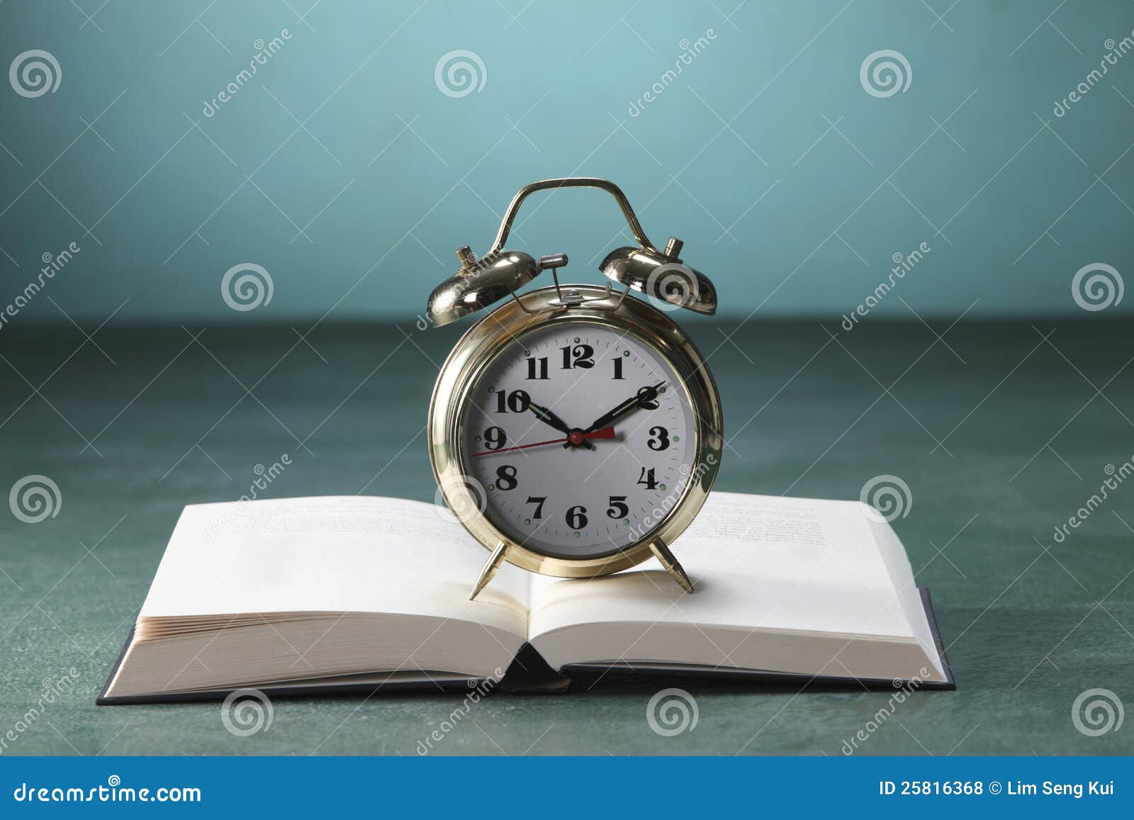 Alarm clock on open book stock photo. Image of page, color - 25816368