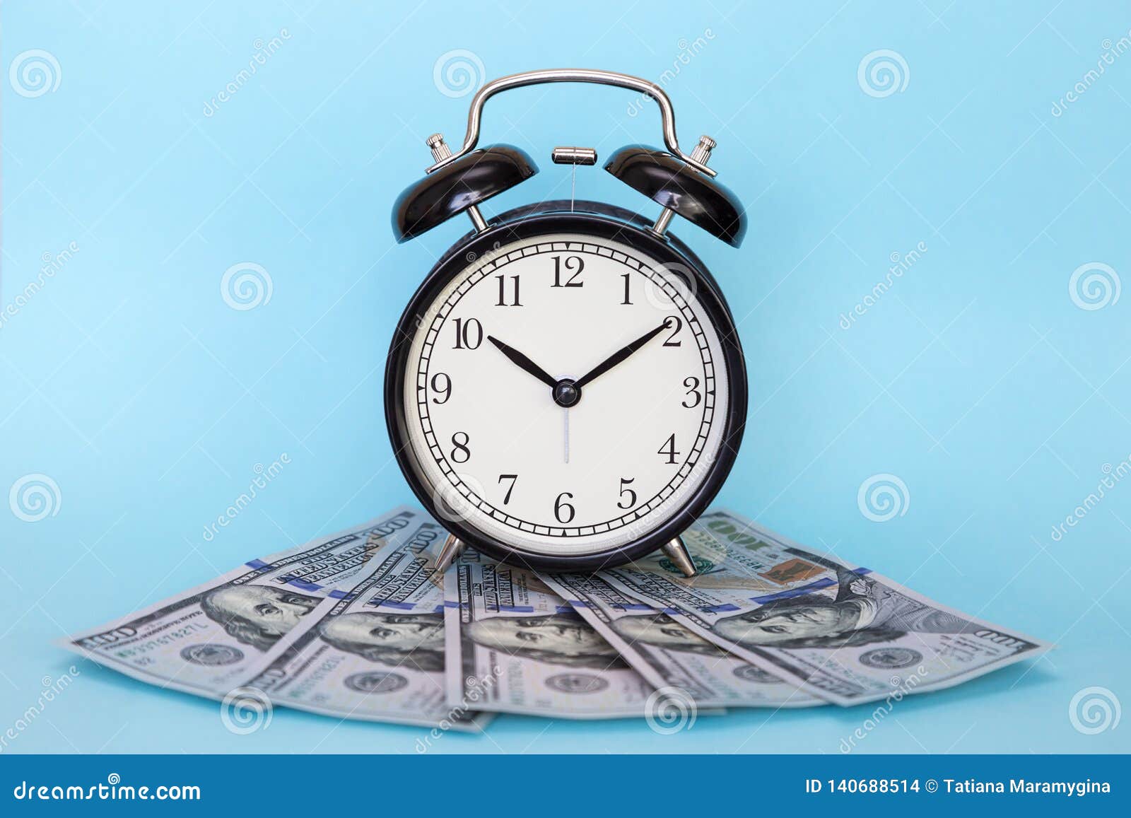 The Alarm Clock Stands on a Stack of Money on a Blue Background Stock ...