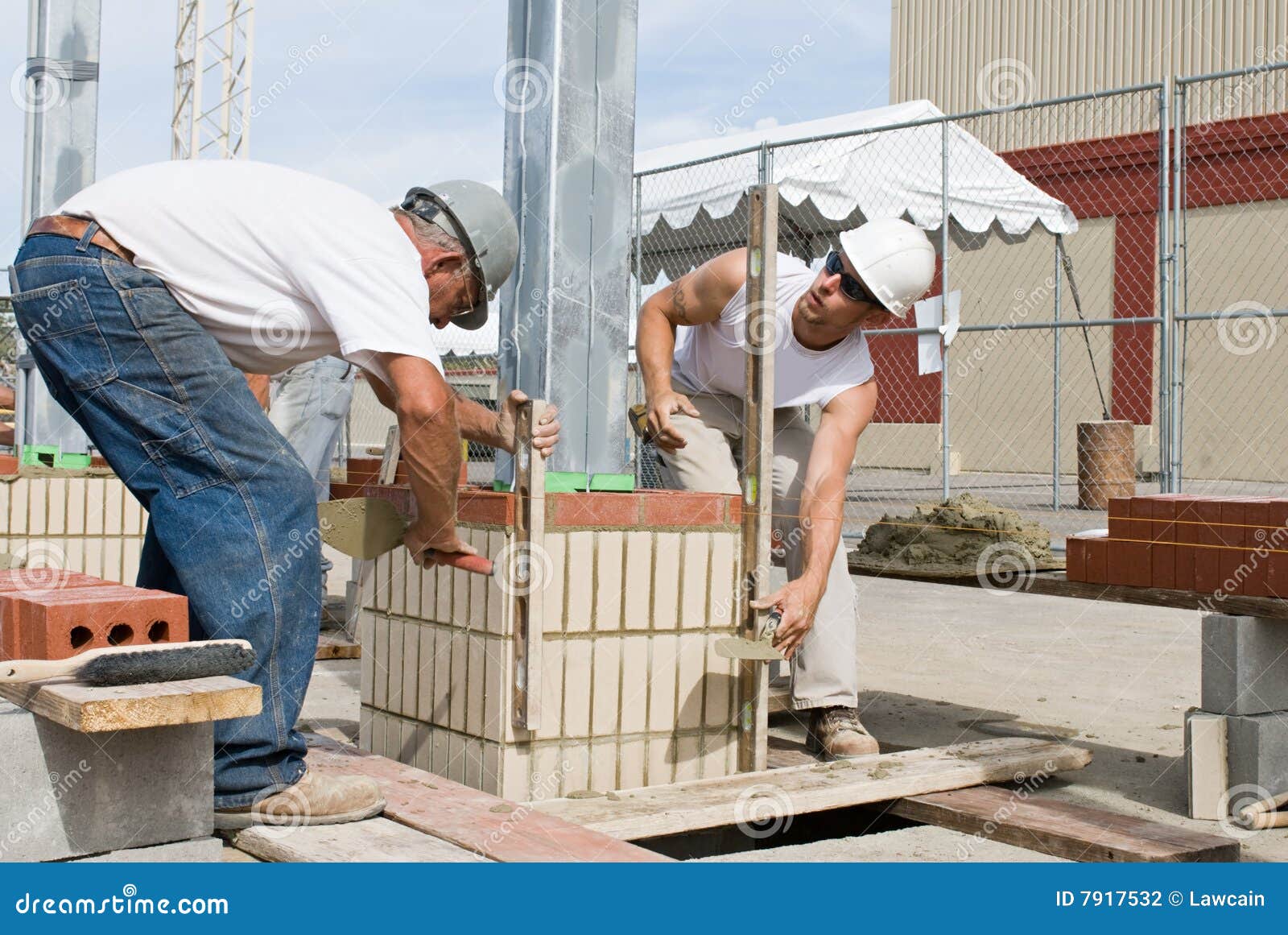 Albañiles que usan niveles foto de archivo. Imagen de contratistas ...