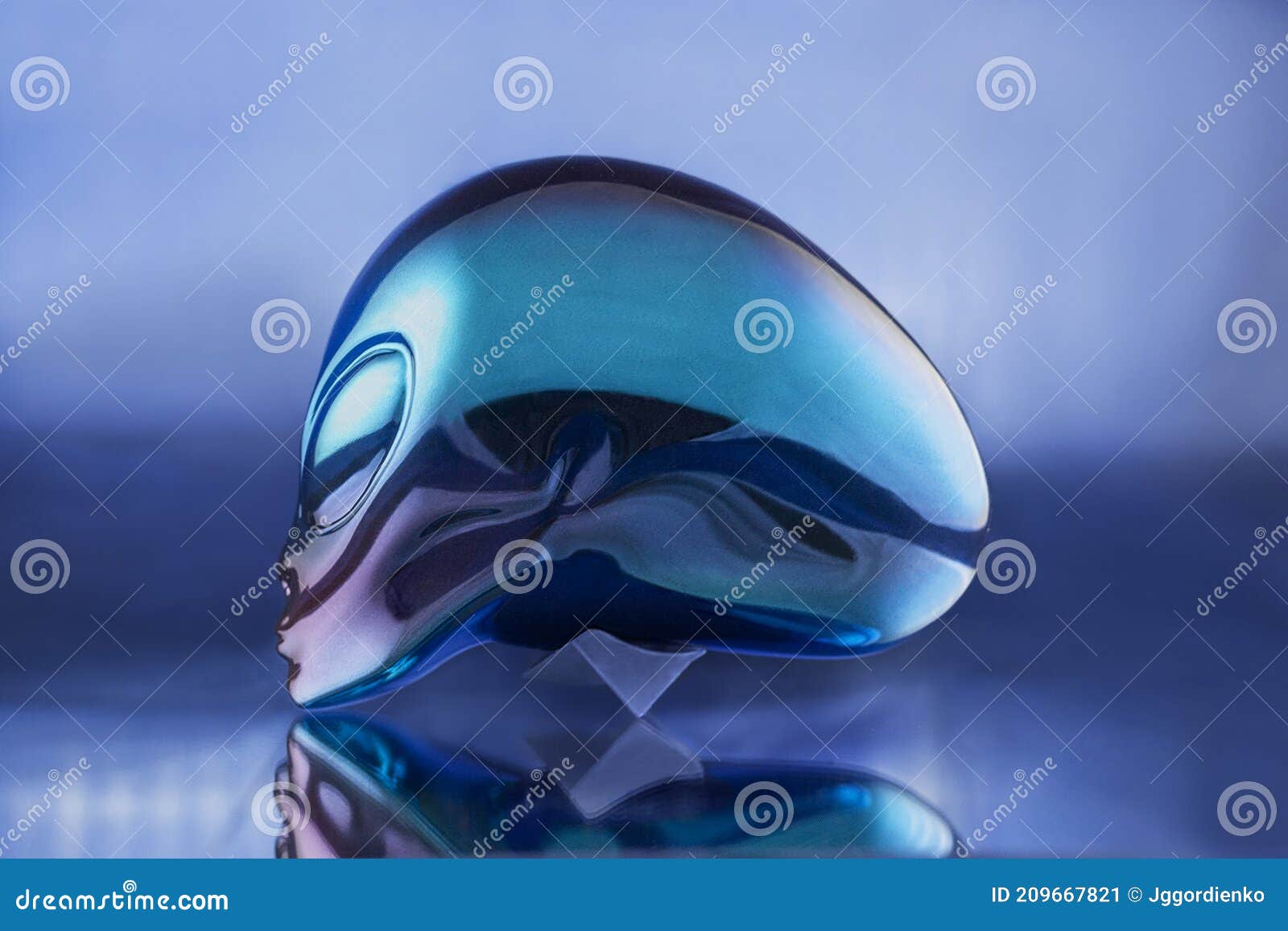 Alien Metal Head Statue on Blue Background on the Table Stock Image ...