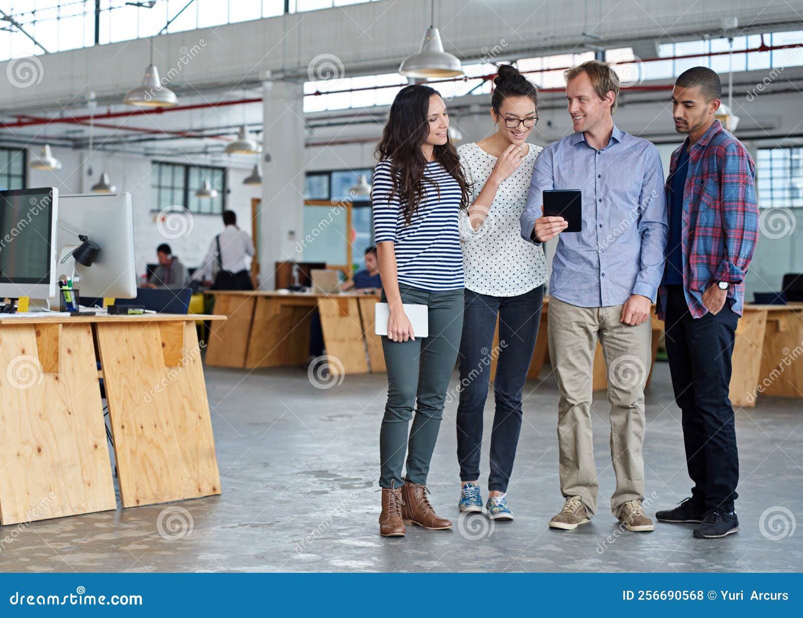 All the Latest on the Go. Open Plan Office with Group of Staff Standing ...