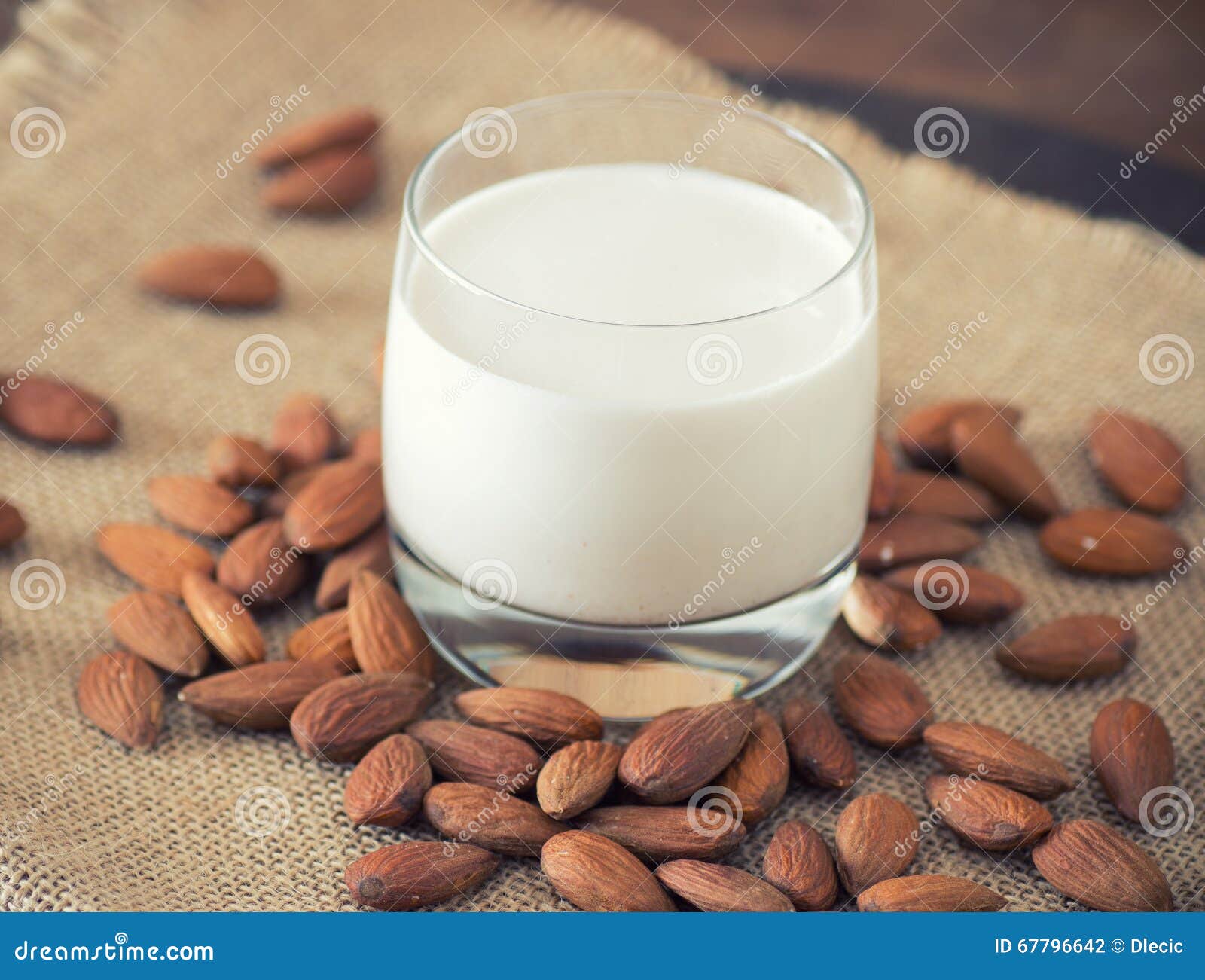 Almond Milk In Glass Bottle With Almonds In A Bowl On The Table Blurred ...