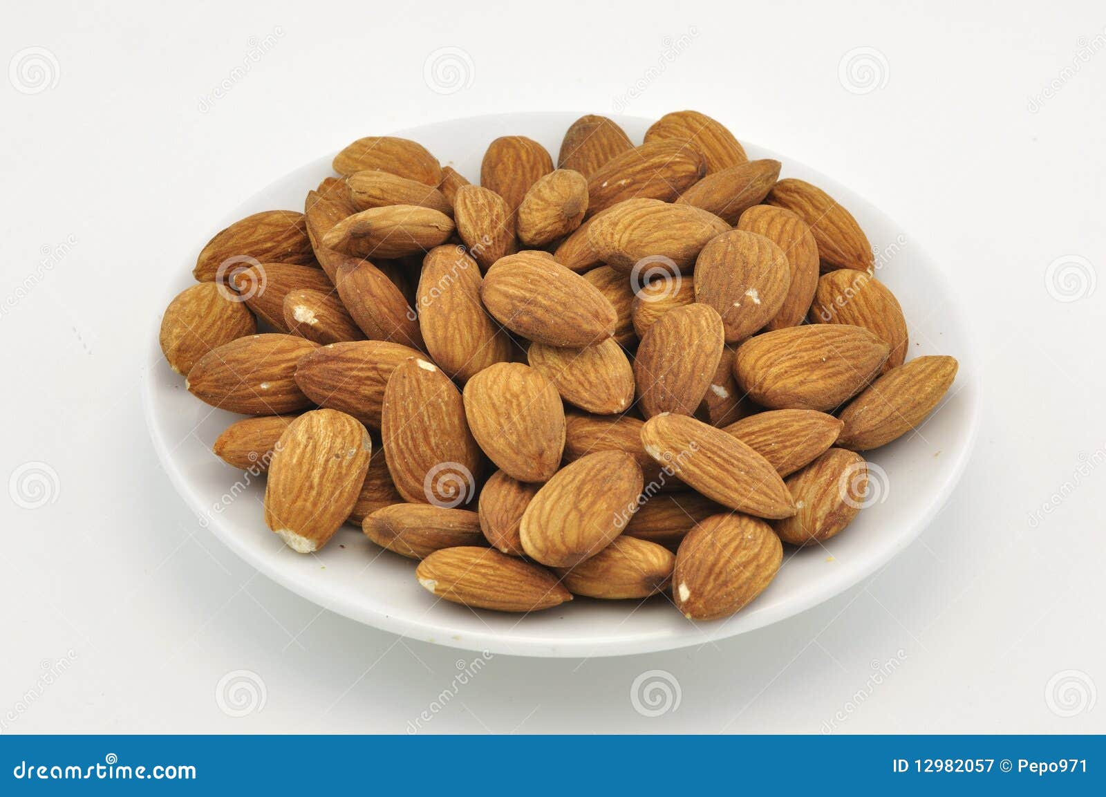 Almonds on plate stock image. Image of snacking, salted - 12982057
