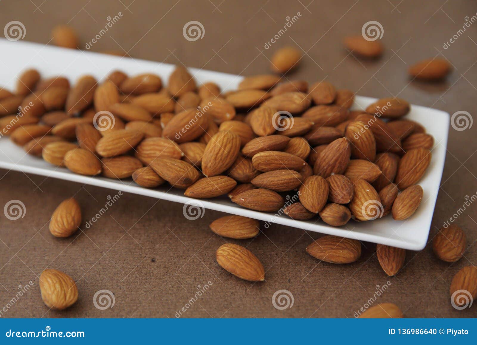 Almonds on a plate stock photo. Image of roasted, hazelnut - 136986640