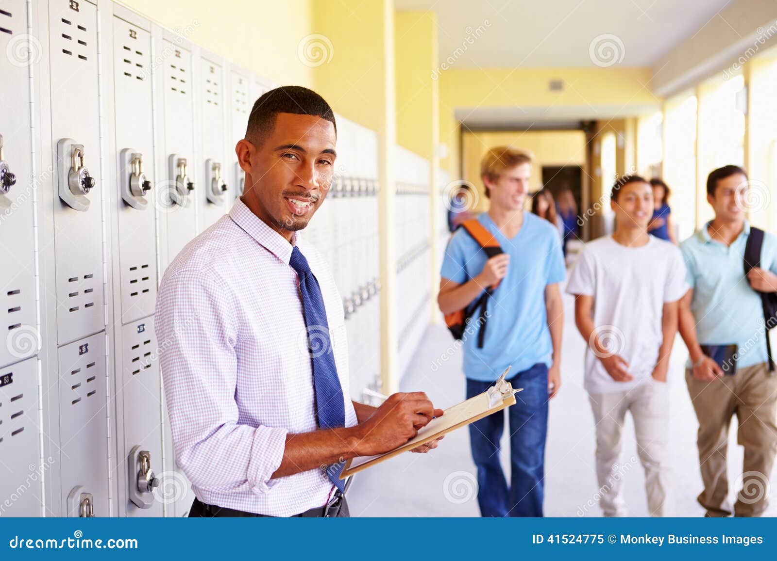 Alto Profesor De Escuela De Sexo Masculino Standing By Lockers Imagen De Archivo Imagen De
