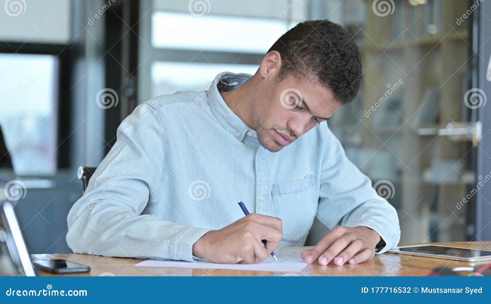 The Ambitious African Man Writing on Paper with Pen Stock Photo - Image ...