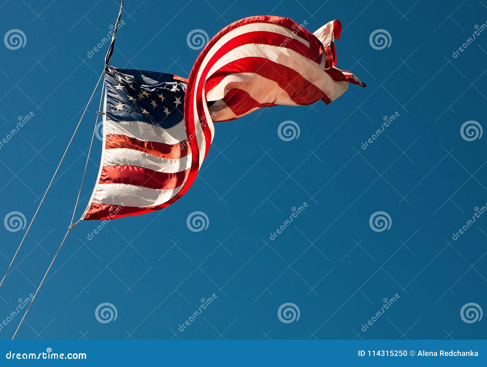 American Flag Blowing in the Wind on the Blue Sky Stock Photo - Image ...