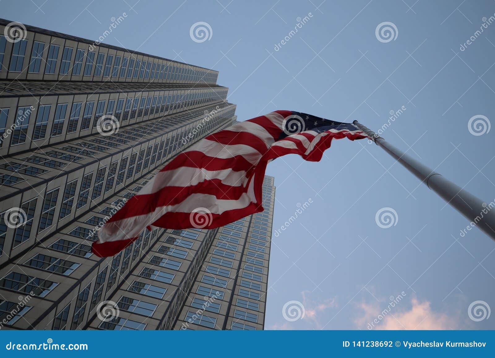 American Flag Fluttering in the Wind Against a Skyscraper Stock Photo ...