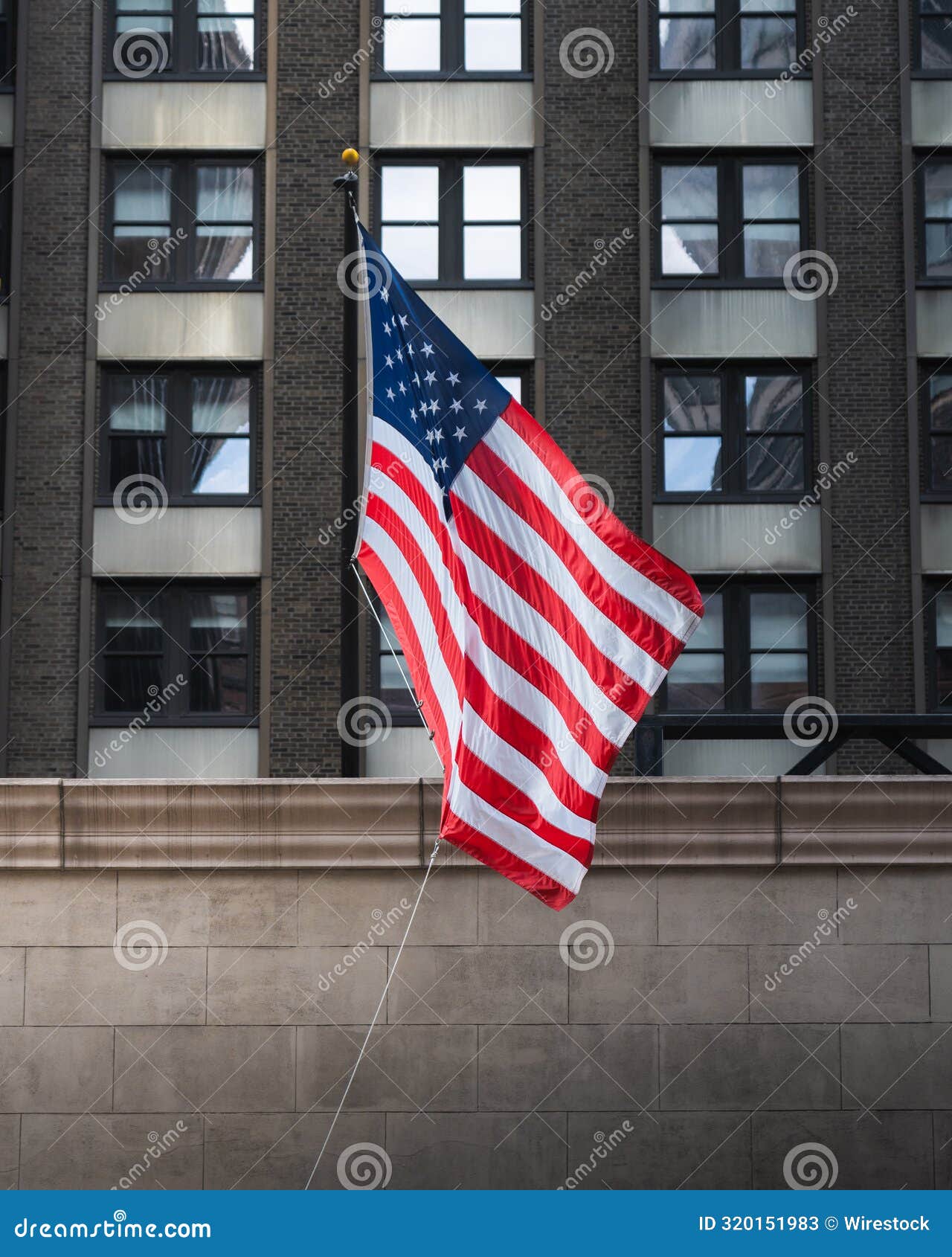 An American Flag Flying from the Top of a Building in Front of Large ...