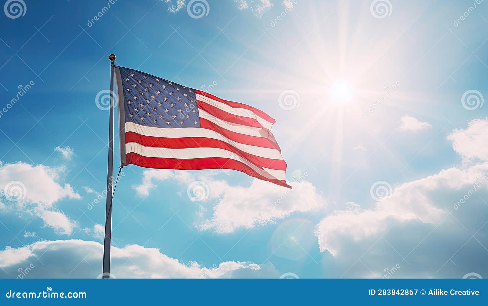 American Flag Waving in the Wind Against a Blue Sky with Sun Rays Stock ...