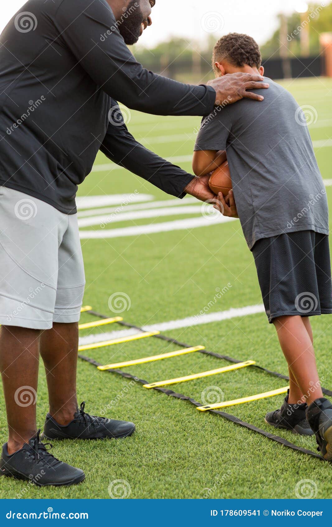 American Football Coach Training a Young Athlete. Stock Image - Image ...