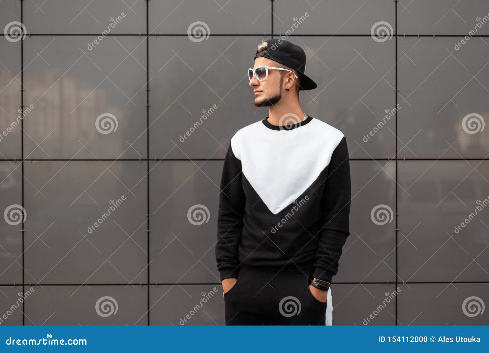 American Young Hipster Man In Stylish Black Cap In Trendy Sunglasses In