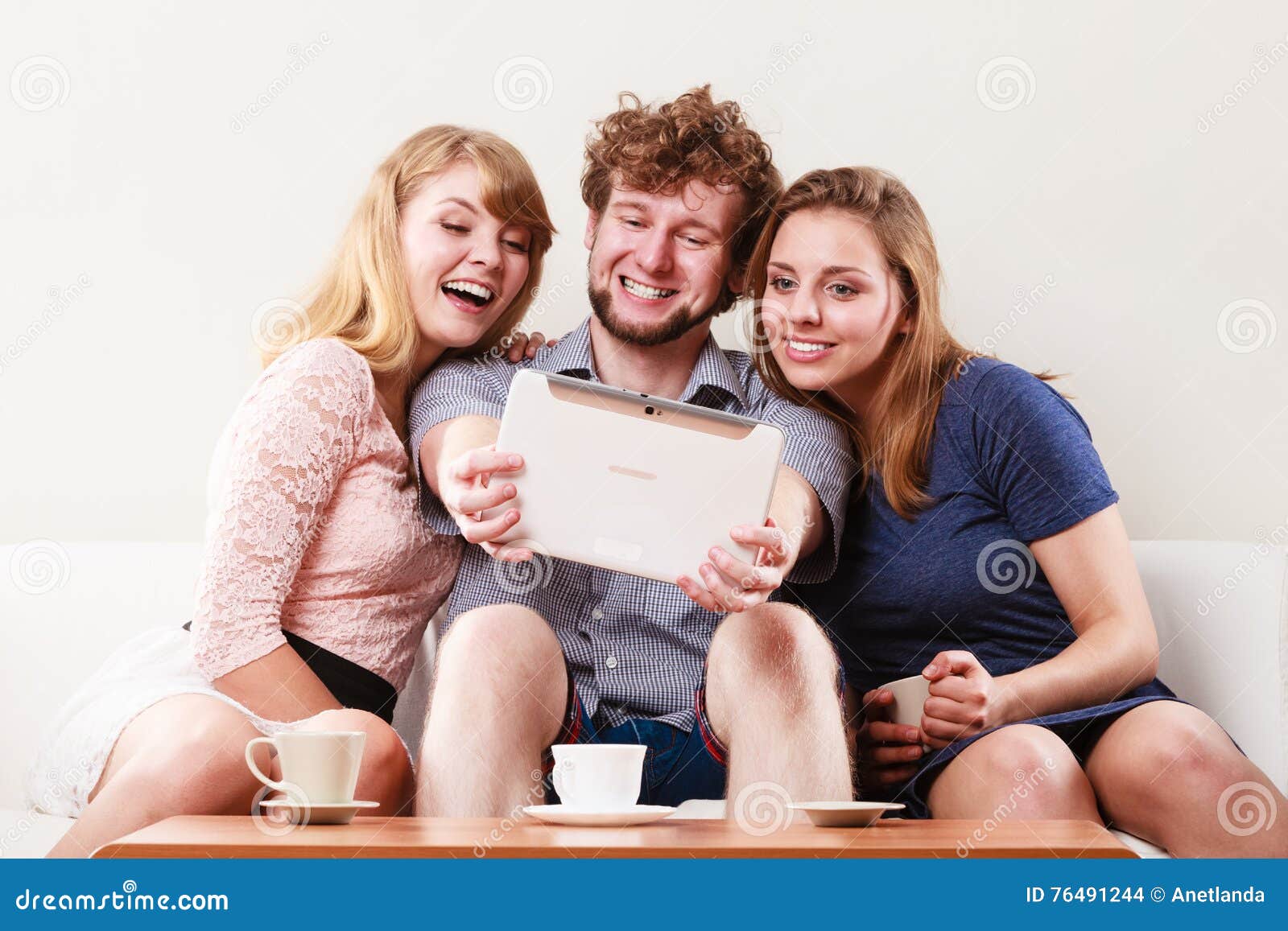 Amigos Que Relajan Internet De La Ojeada En La Tableta Foto de archivo ...