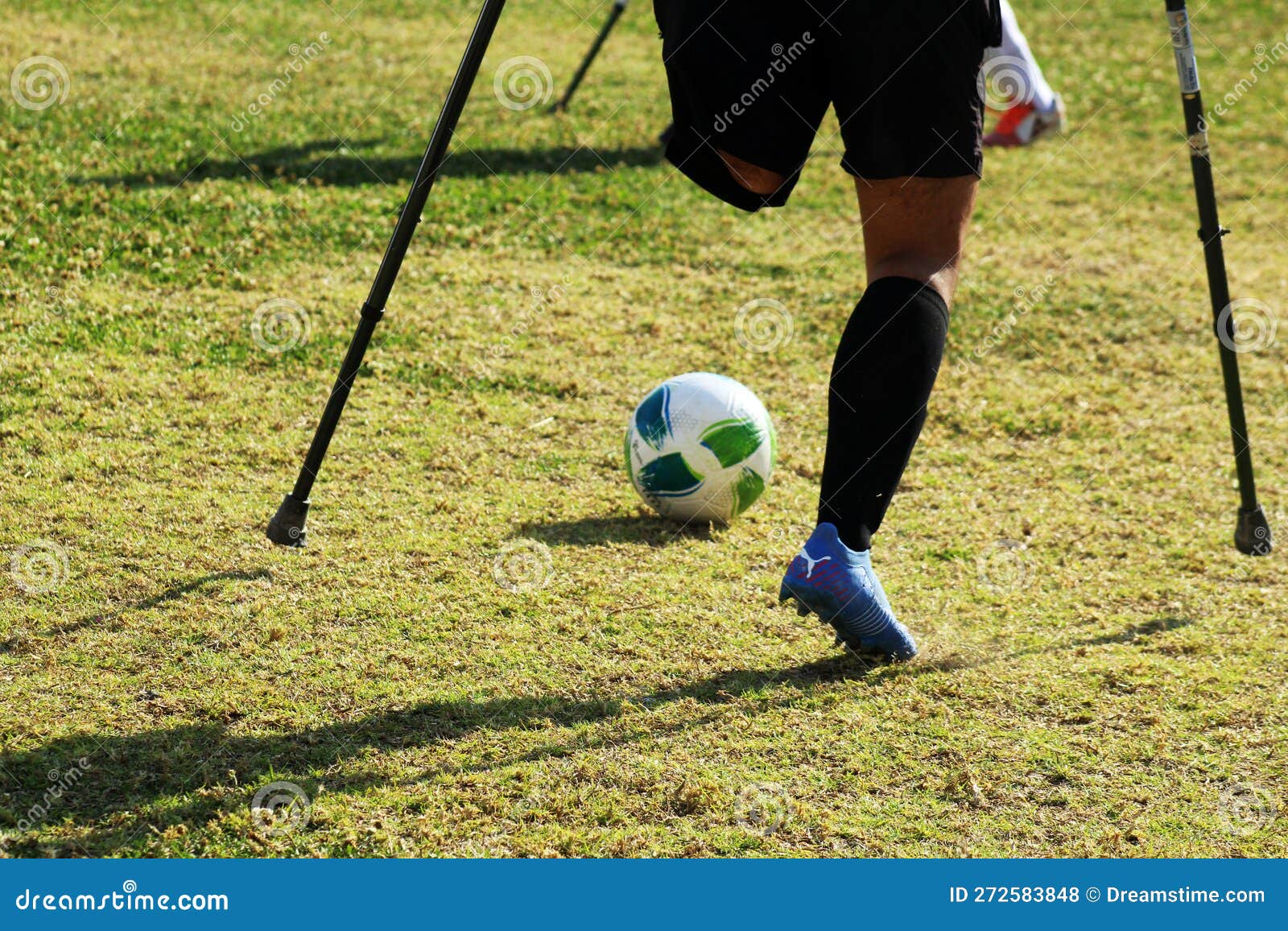 An Amputee Man Playing Soccer with the Help of Crutches Stock Photo ...