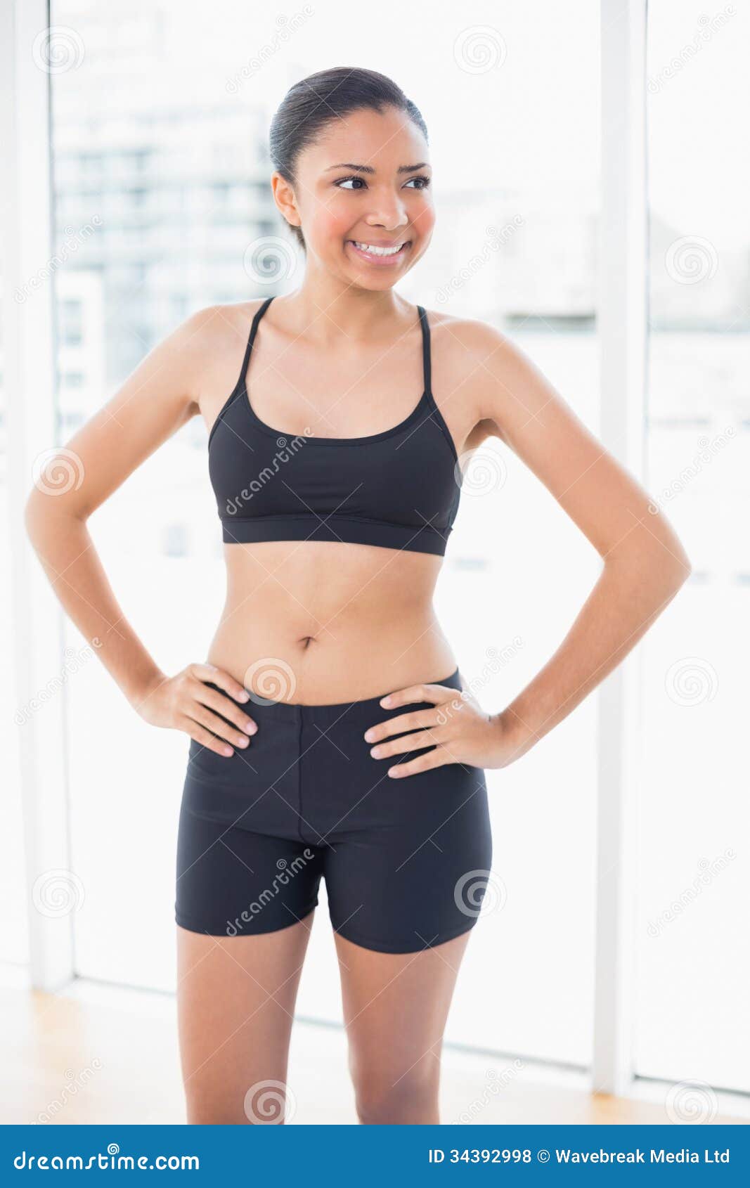 Amused Dark Haired Model In Sportswear Posing With Hands On The Hips