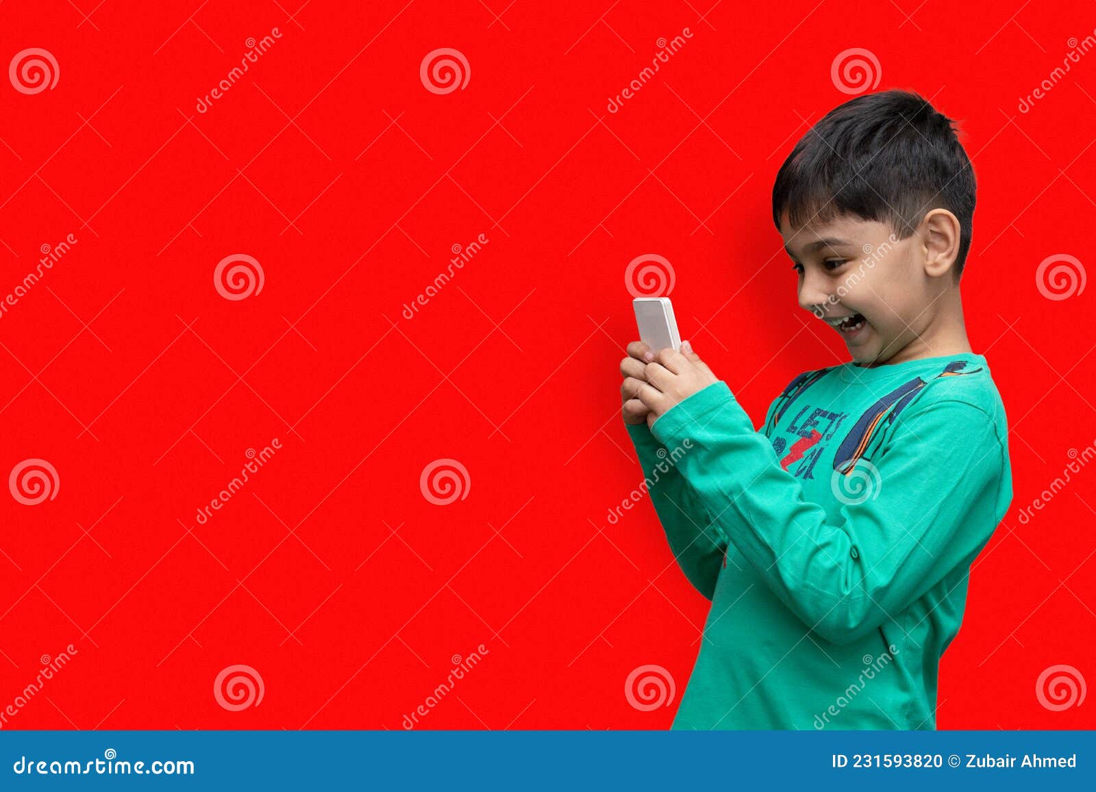 Amused Young Kid Playing Games on Smartphone - Posing at Studio Stock ...
