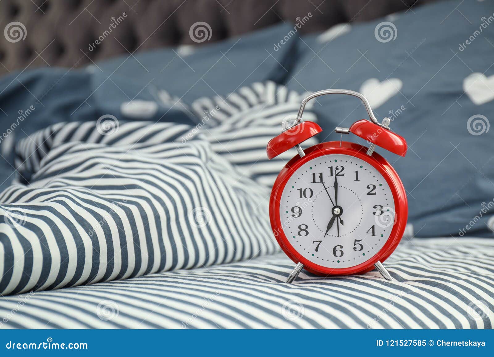 Analog alarm clock on bed stock image. Image of home - 121527585