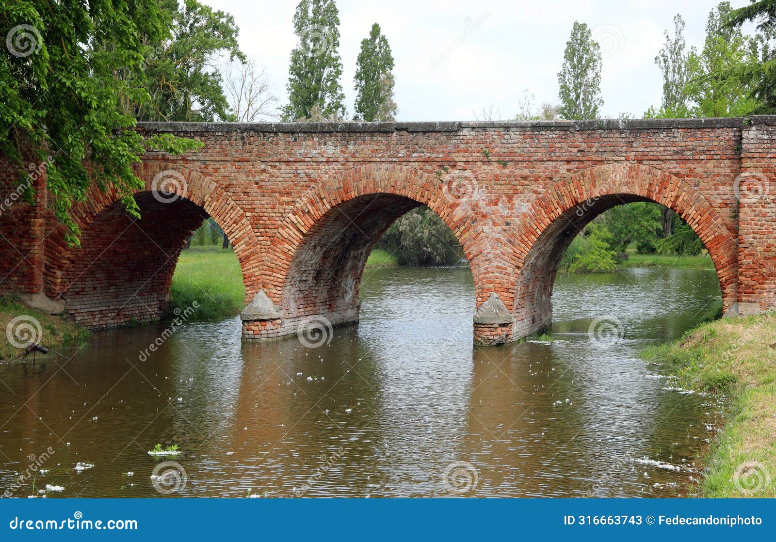 Ancient Three-arched Red Brick Bridge with a Flowing River Underneath ...