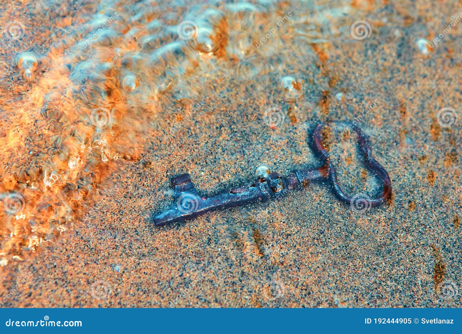 An Ancient Key Lies in the Water on the Yellow Sand of the Beach Stock ...