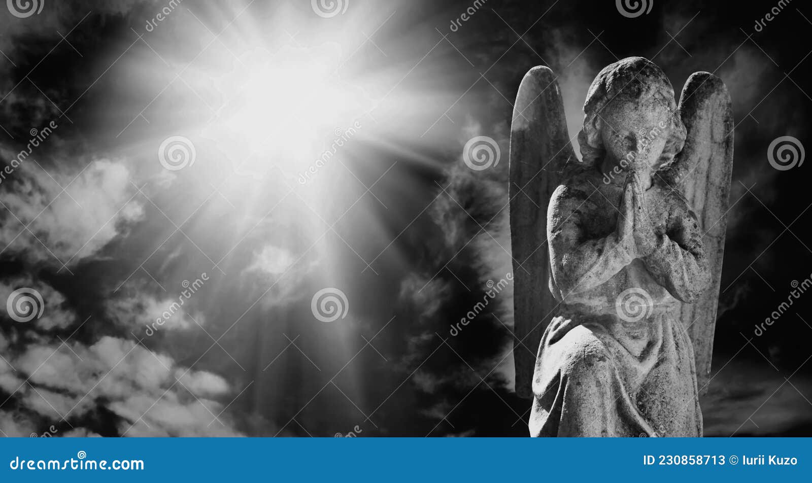 Ancient Statueof Angel in Rays of Light Against Sky with Clouds. Black ...