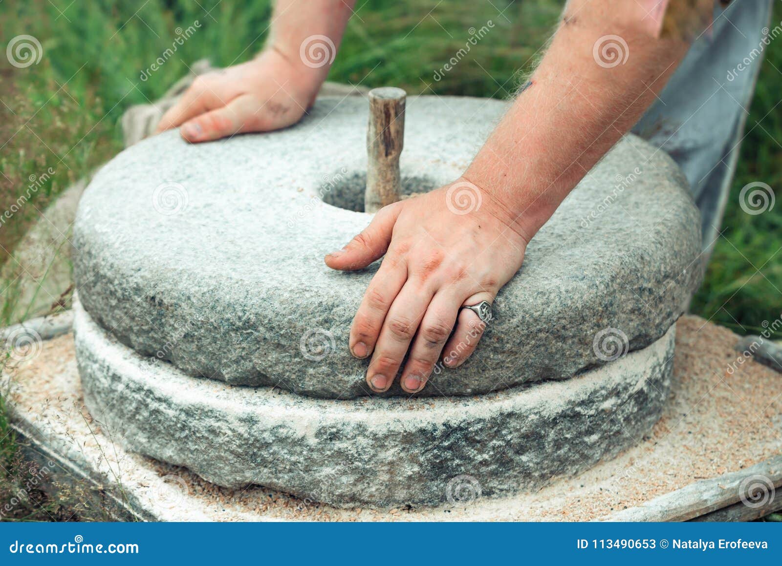 The Ancient Stone Hand Grain Mill. Men`s Hands Rotate a Stone Millstone ... The Ancient Stone Hand Grain Mill. Men`s Hands Rotate a Stone Millstone ...