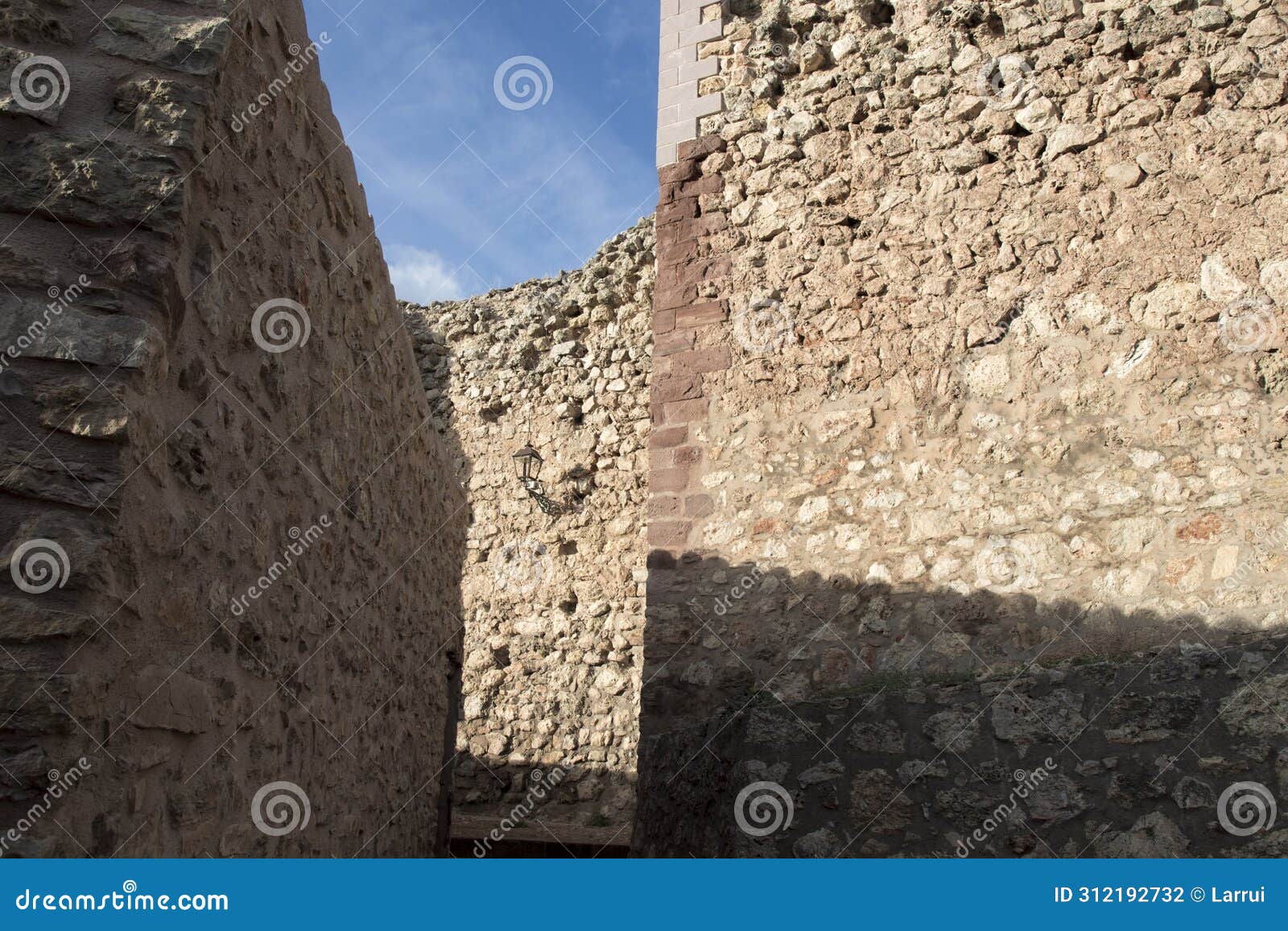 Ancient Stone Walls Under a Clear Sky, Creating a Narrow Pathway ...