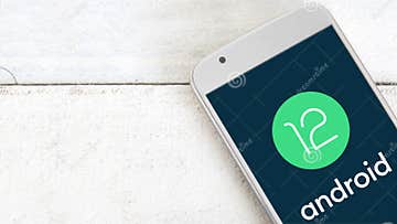 Android 12 Logo on a Screen of a Mobile on a White Wooden Table ...