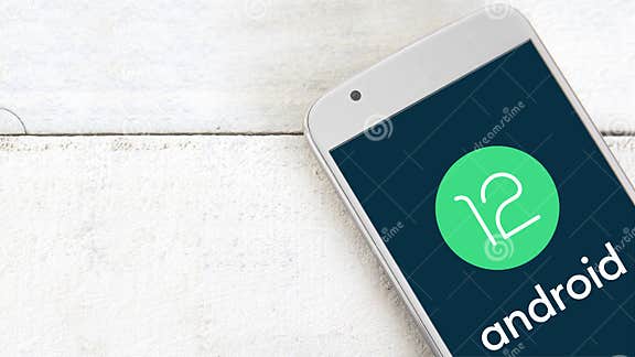 Android 12 Logo on a Screen of a Mobile on a White Wooden Table ...