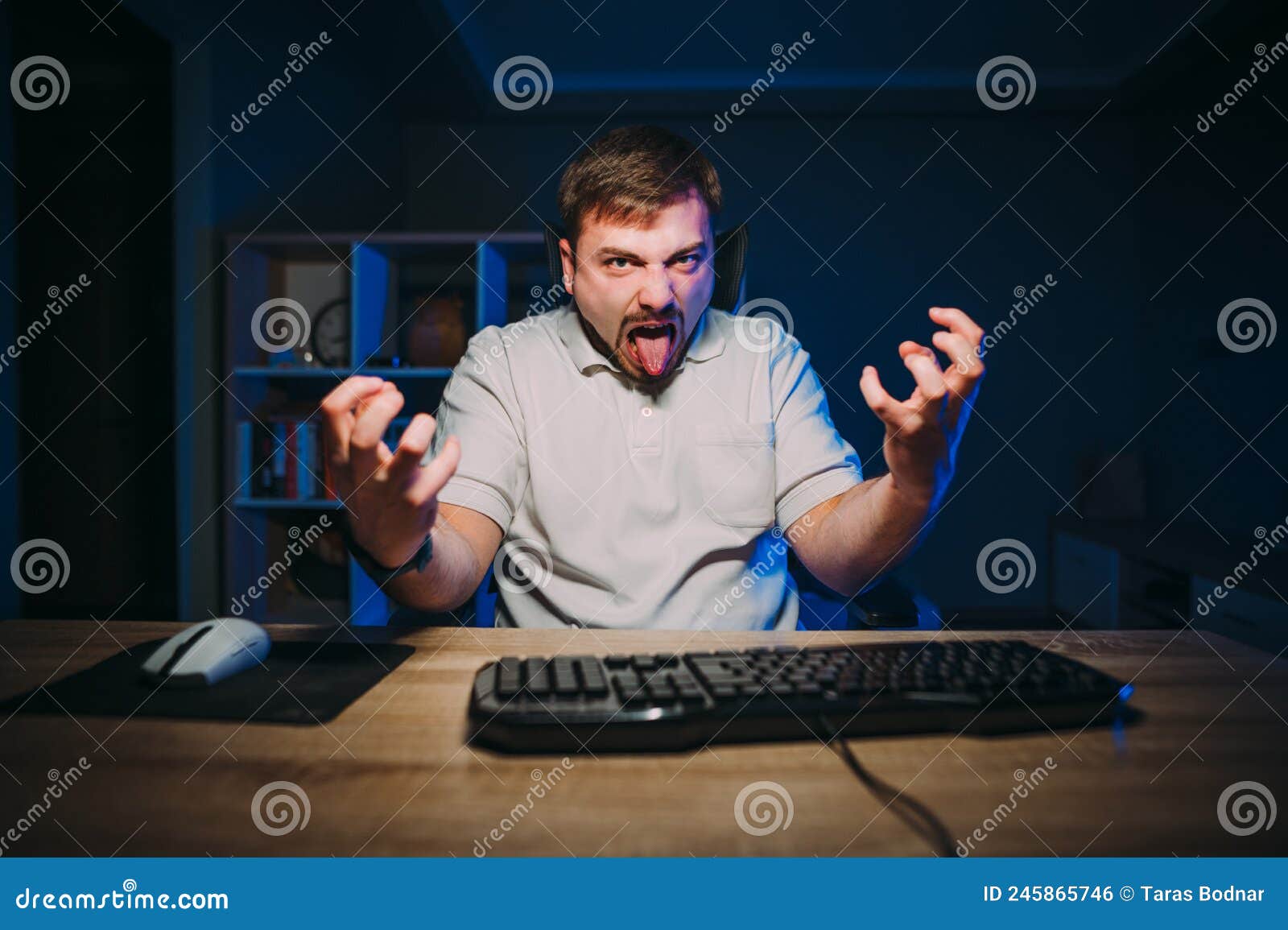 An Angry Adult Man with a Beard Sits at Night at the Computer at Work ...