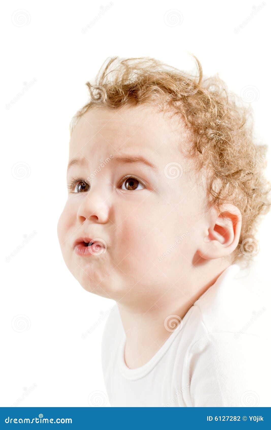 Angry Baby Girl In White Knitted Dress Sits Behind A Laptop Among Toys ...