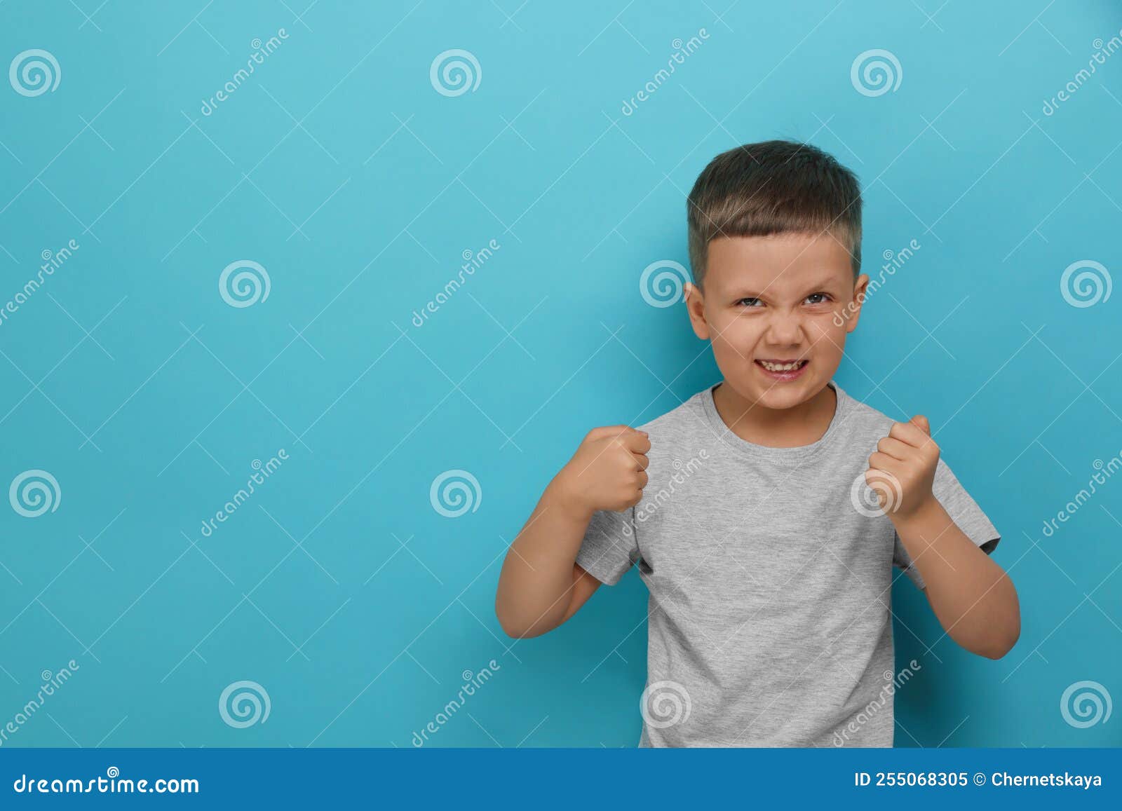Angry Boy on Light Blue Background, Space for Text. Aggressive Behavior ...